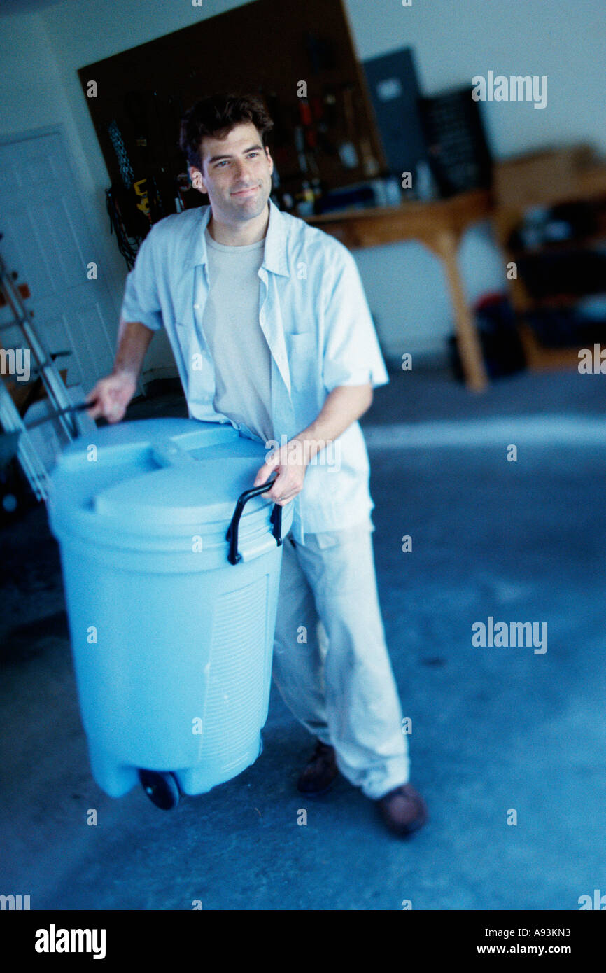 High angle view of a young man carrying a trash can Stock Photo - Alamy