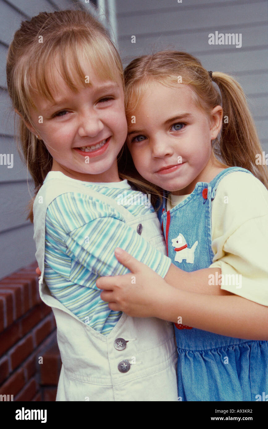 Portrait of two girls hugging each other Stock Photo - Alamy