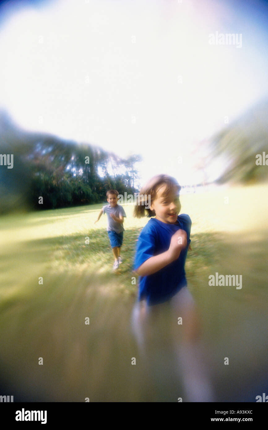 Boy chasing a girl on a lawn Stock Photo - Alamy