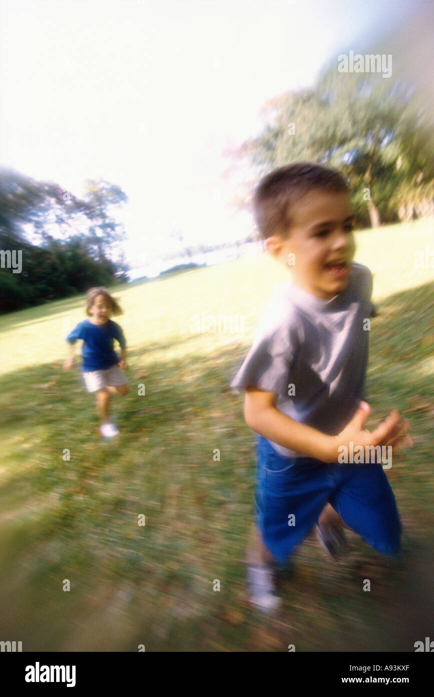 Girl chasing a boy on a lawn Stock Photo - Alamy