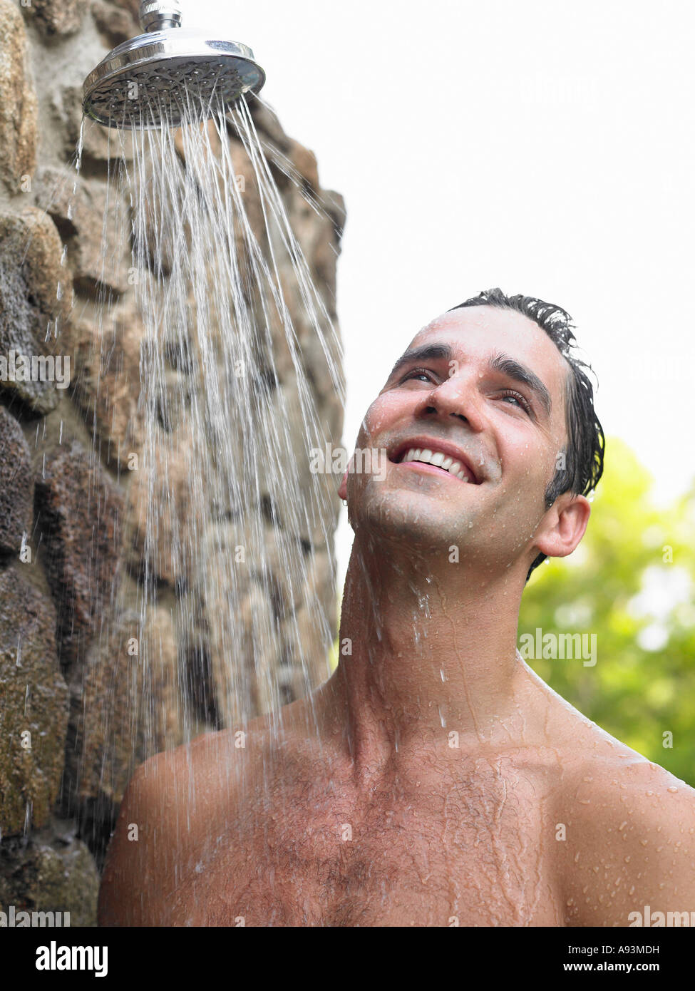 Mid adult man taking shower, smiling, outdoors Stock Photo - Alamy