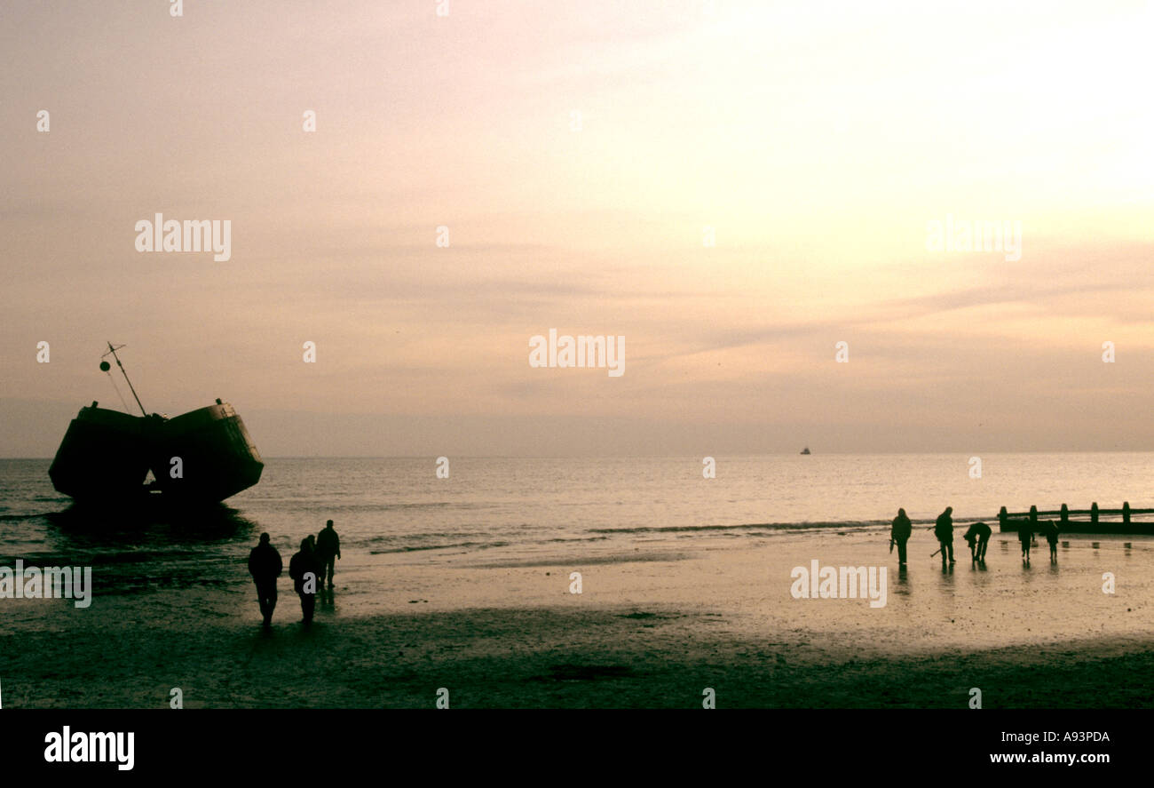 Walkers at sunset low tide with dredger on beach Rustington near ...
