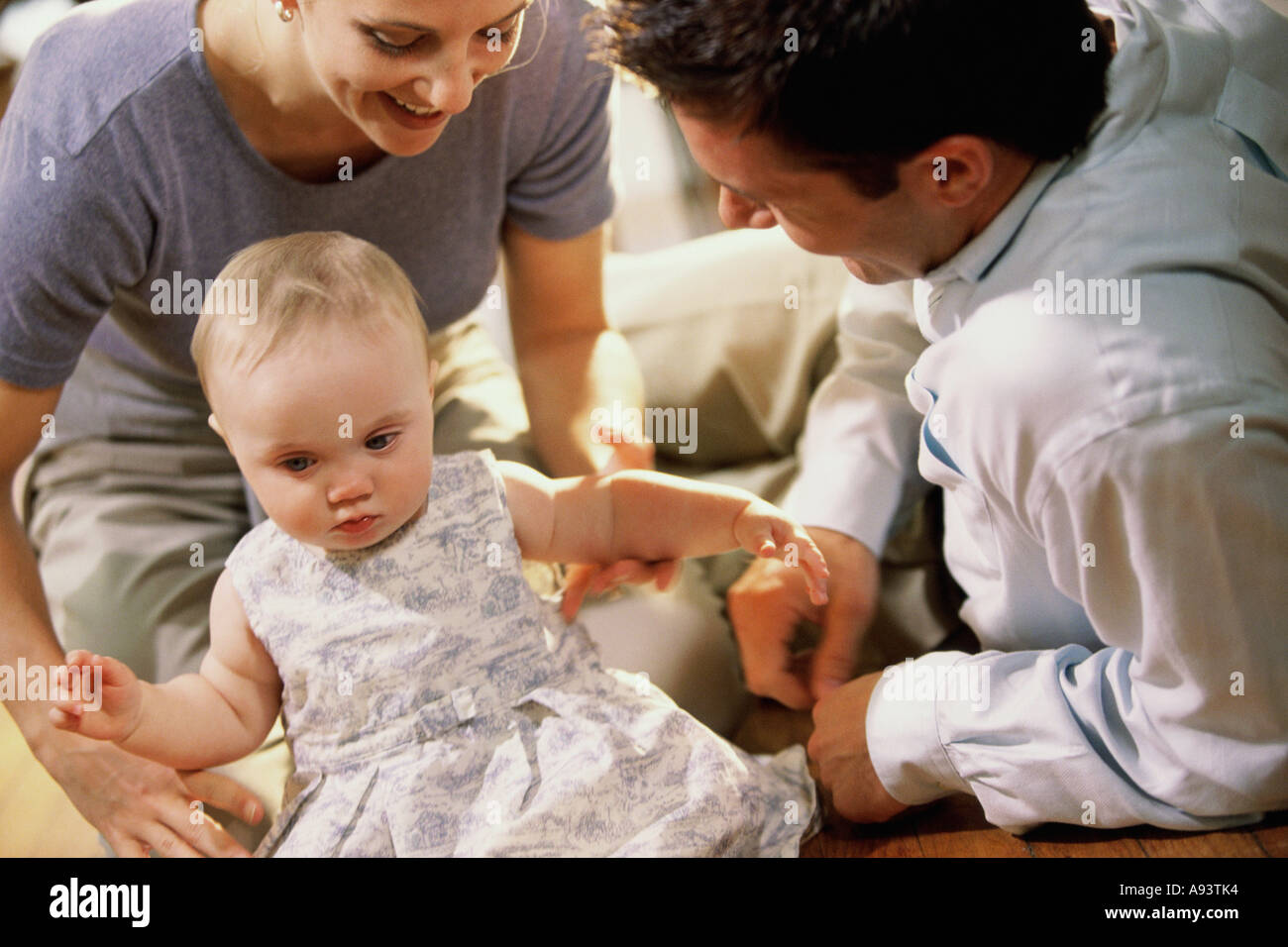 Parents looking at their daughter smiling Stock Photo - Alamy