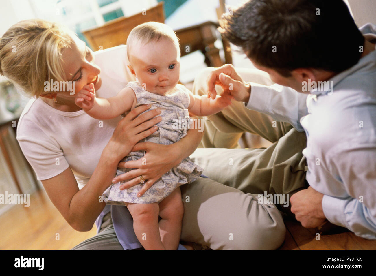 Parents looking at their daughter smiling Stock Photo - Alamy