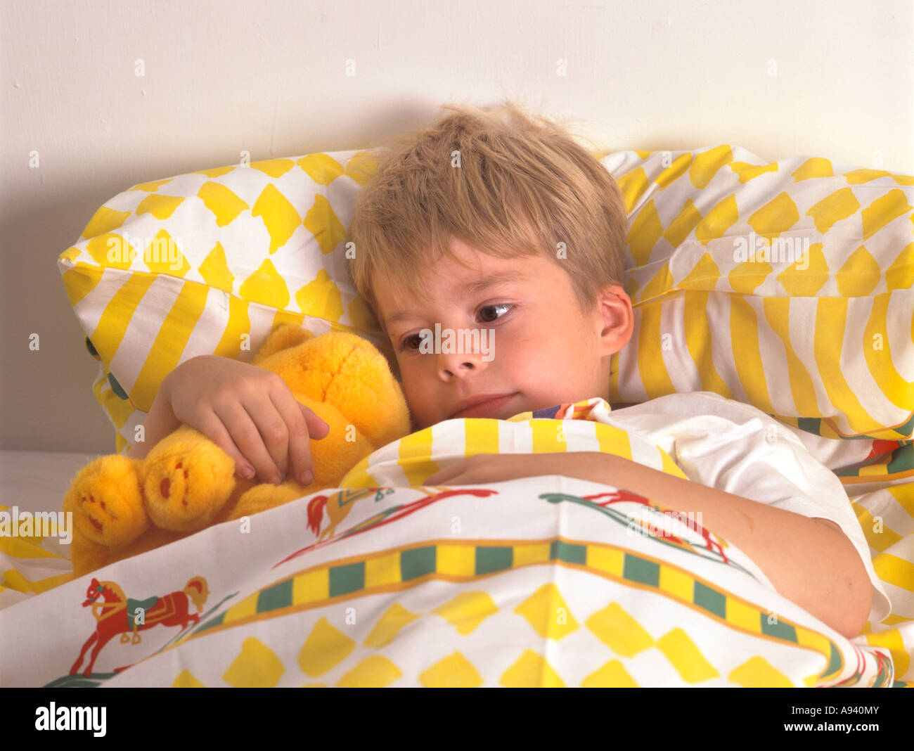 Little boy awake in bed with his toy pet Stock Photo - Alamy