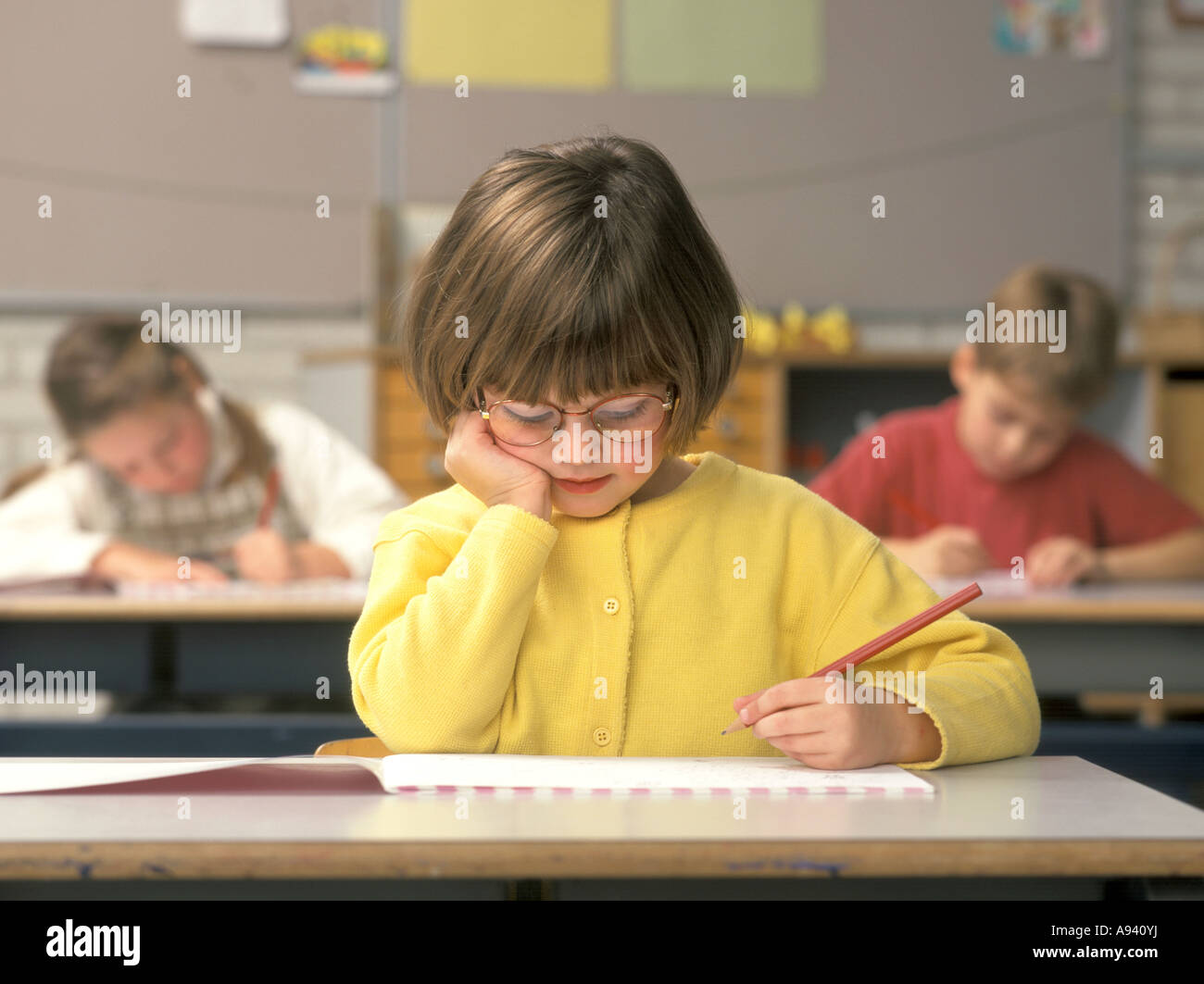 Girl is writing in schoolclass Stock Photo - Alamy