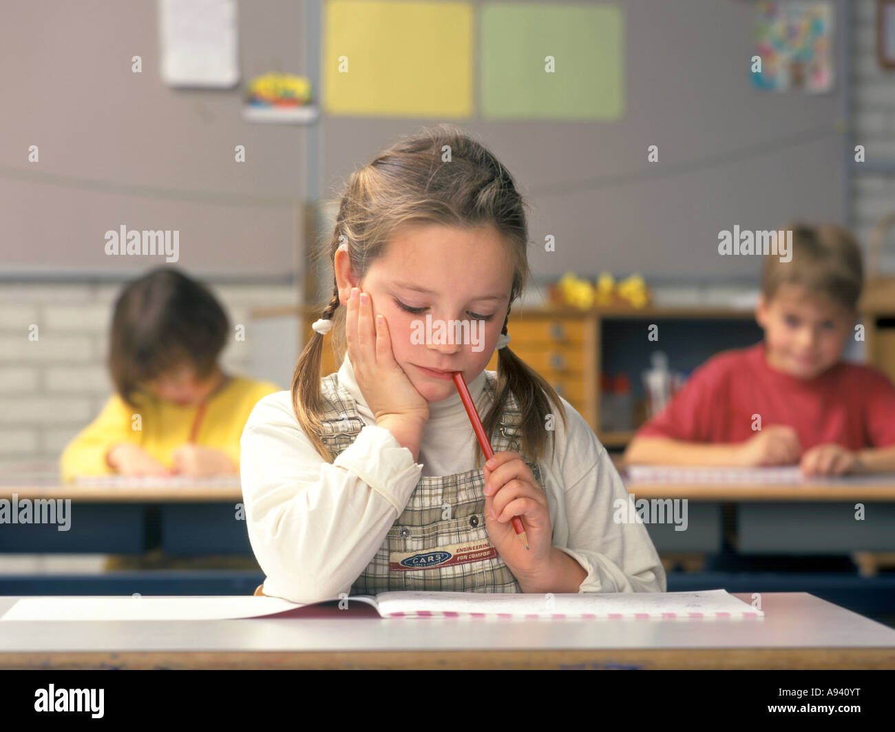 Girl is writing in schoolclass Stock Photo - Alamy
