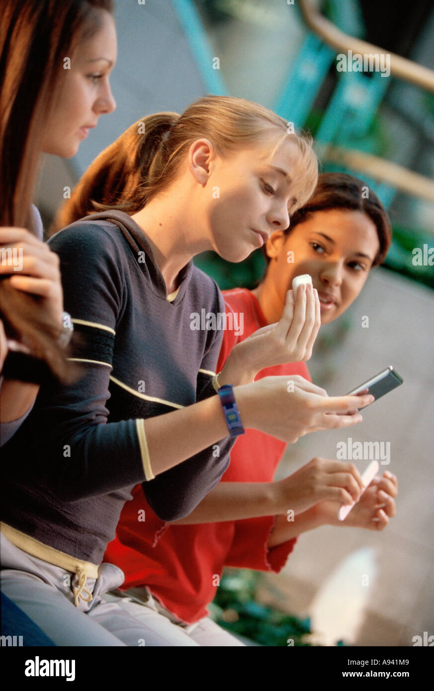 Three teenage girls grooming themselves Stock Photo - Alamy