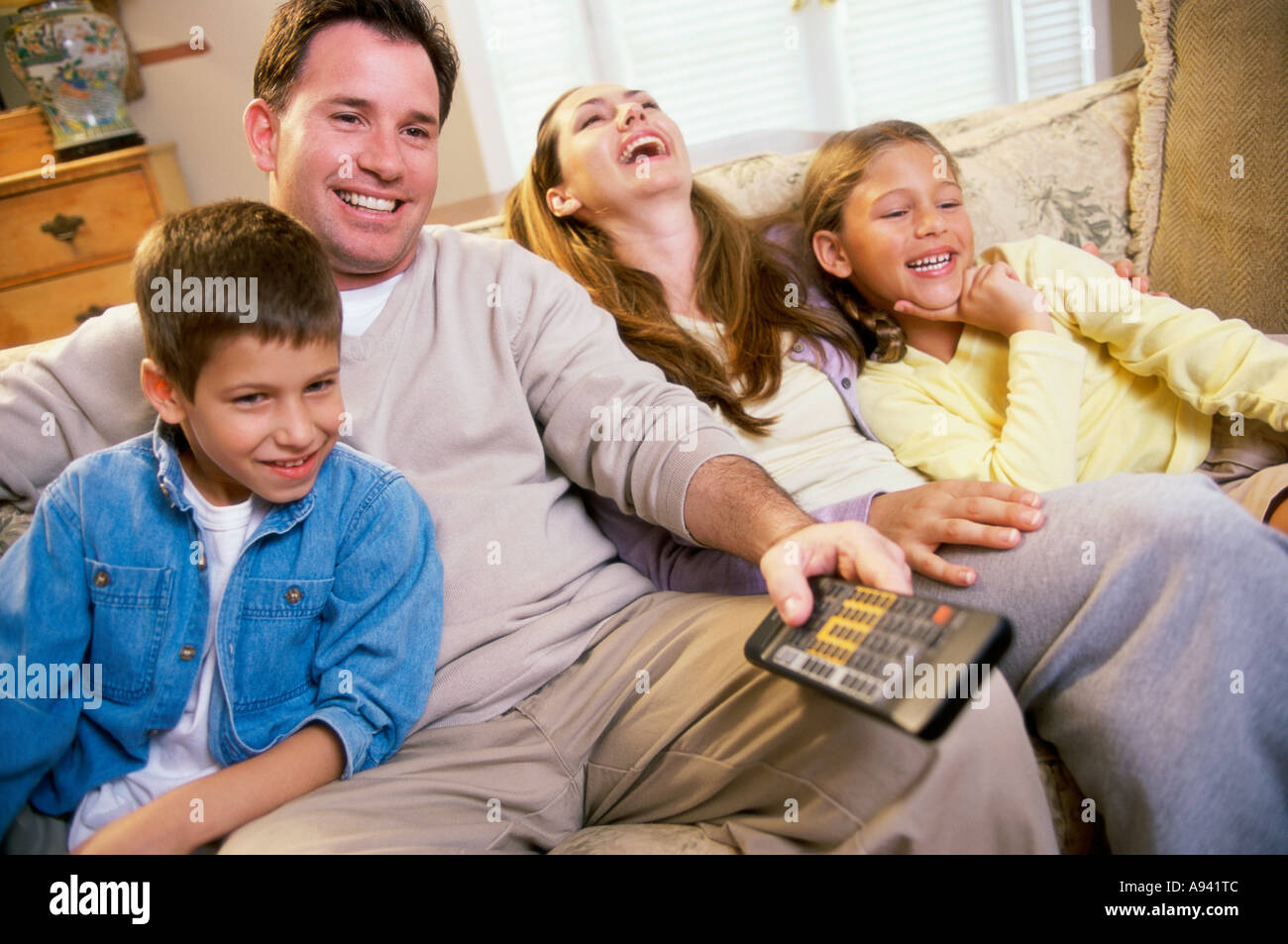 Parents watching television with their son and daughter Stock Photo - Alamy
