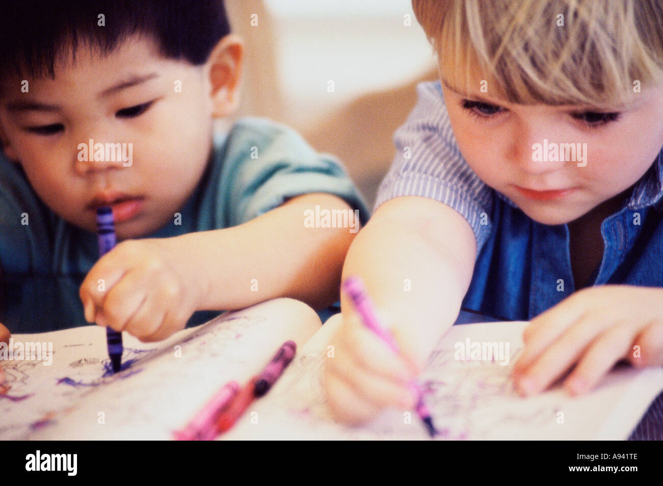 Close-up of two boys drawing with crayons Stock Photo - Alamy