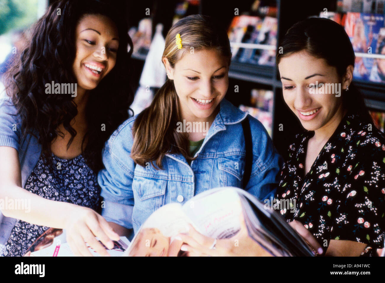 Three teenage girls reading a magazine Stock Photo - Alamy