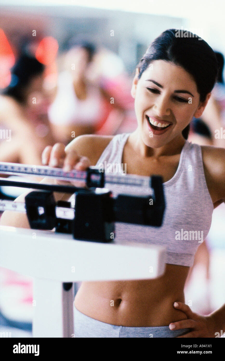 Young woman standing on a weight scale Stock Photo - Alamy