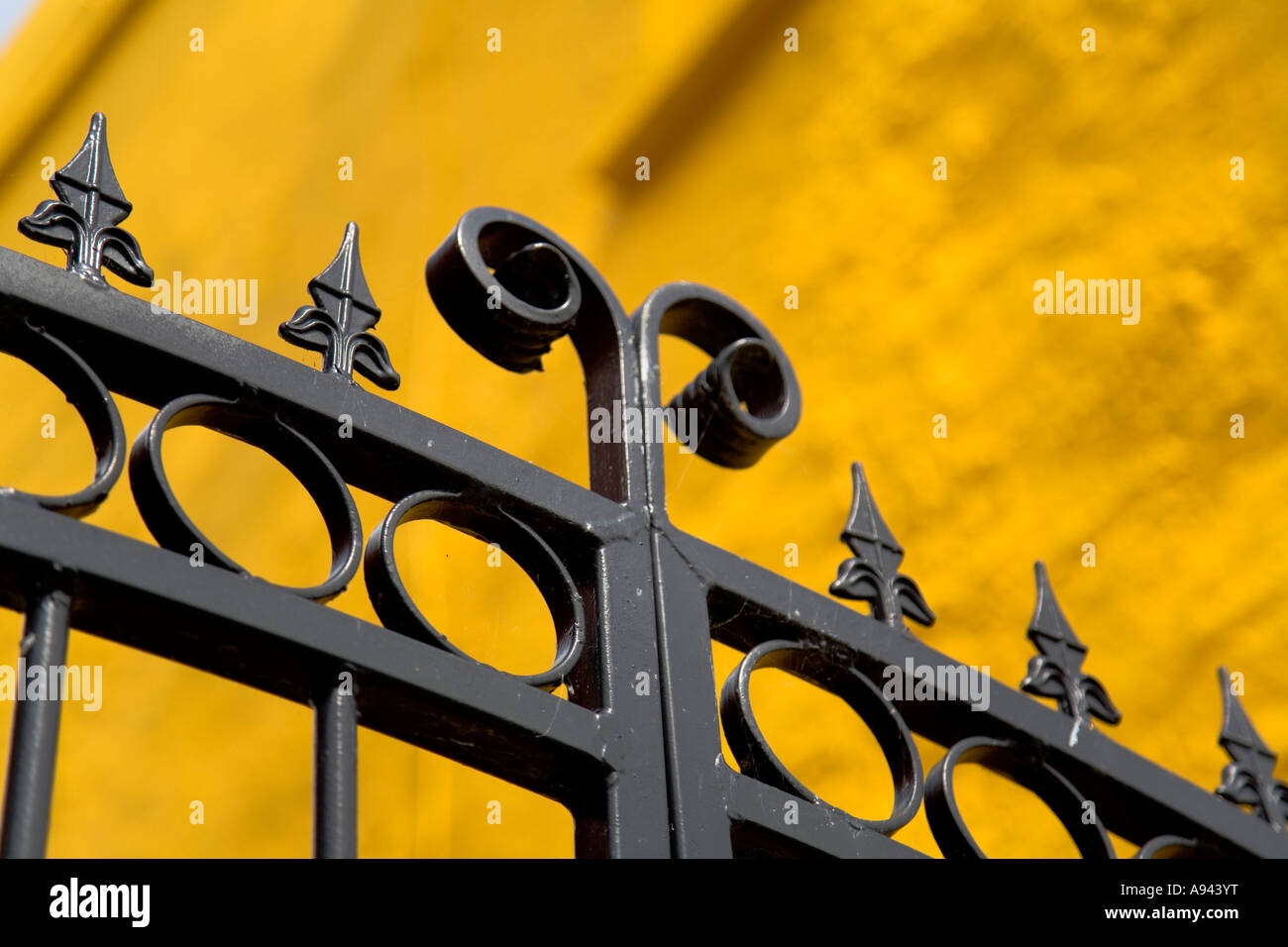 yellow wall with black metal gate Stock Photo - Alamy
