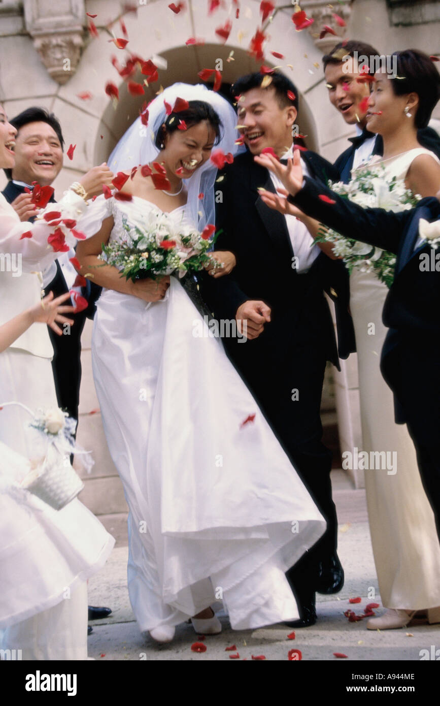 Wedding guests throwing rose petals on a newlywed couple Stock Photo ...