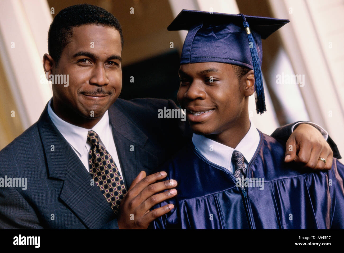 Portrait of a father with his teenage graduate son smiling Stock Photo ...