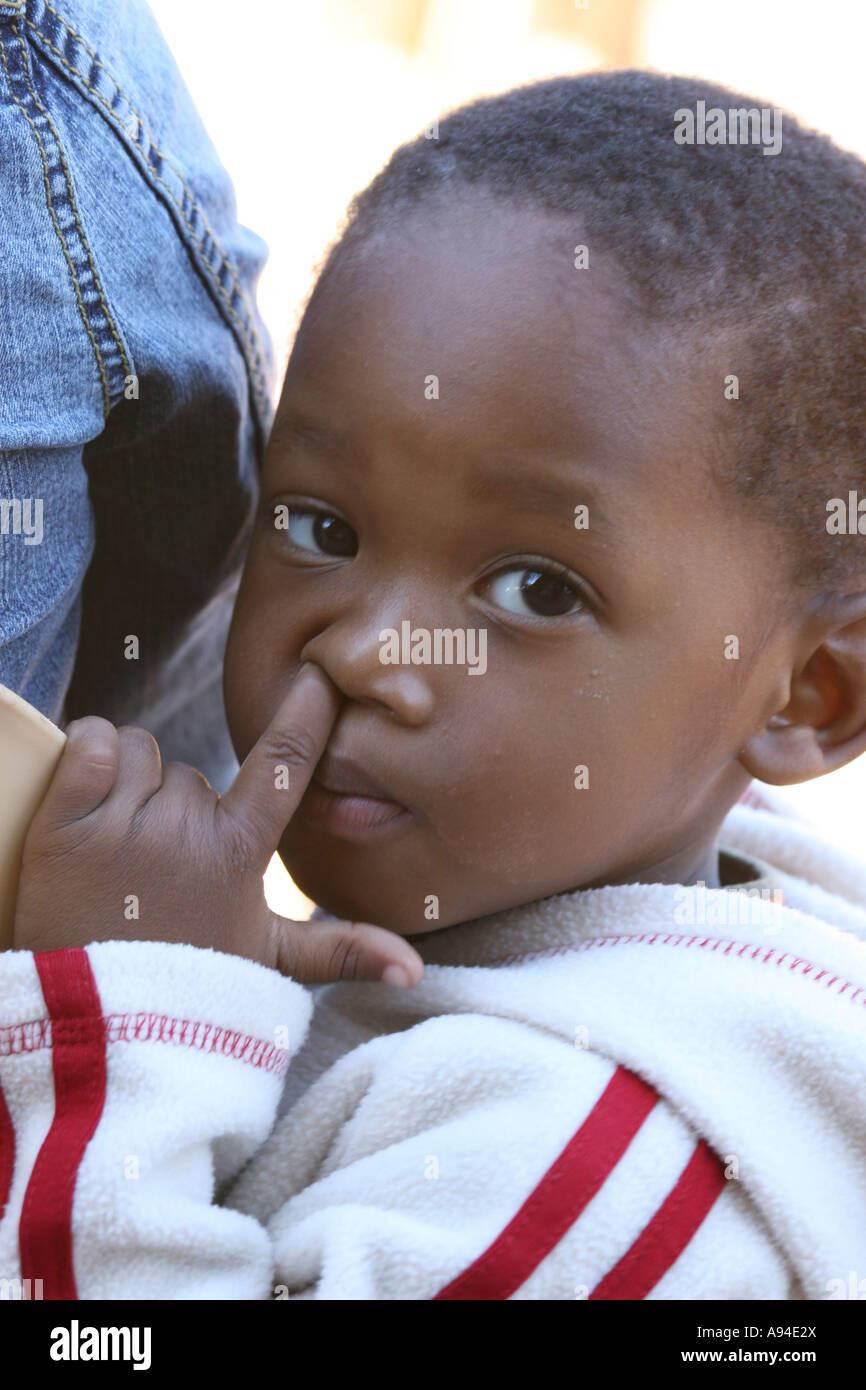 Young Motswana boy poking his finger in one nostril Gaborone Botswana ...