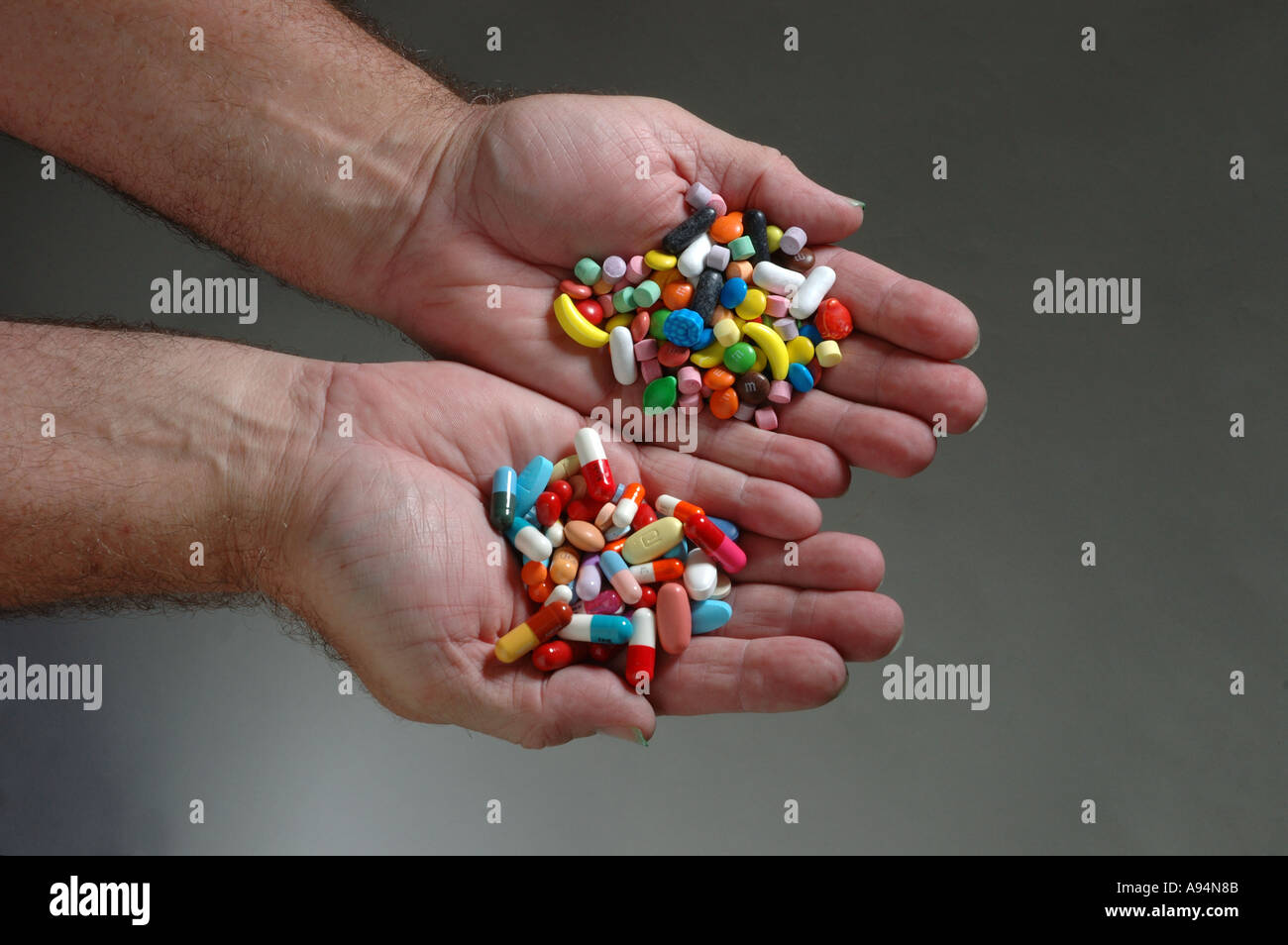 comparison between candy and drugs held in two 2 male hands dsca 3182 ...