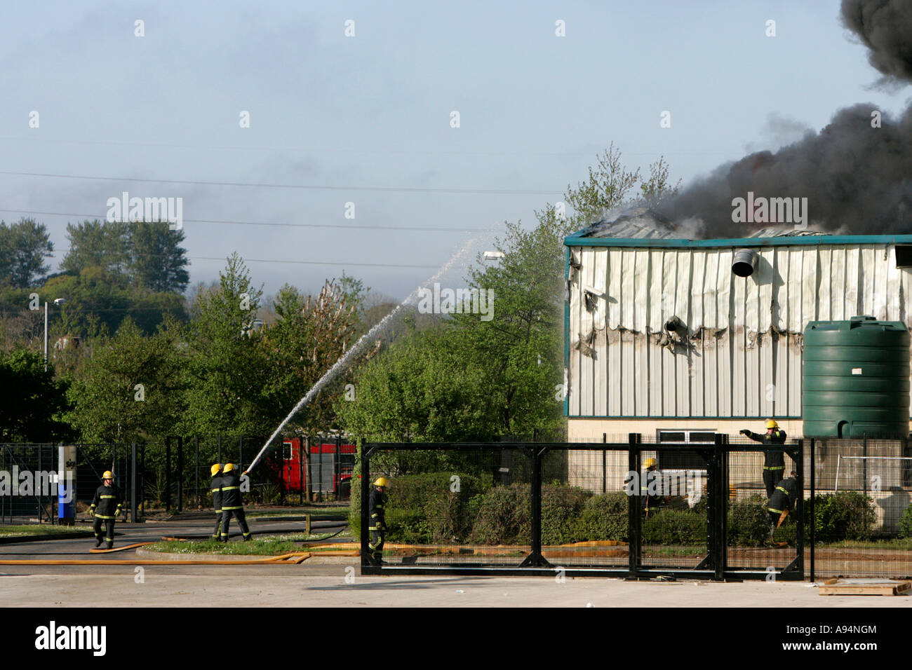 firefighters tackling a fire with water and hoses at medical warehouse ...
