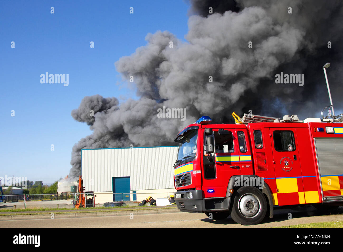 front of fire engine beneath column of smoke as firefighters tackle ...