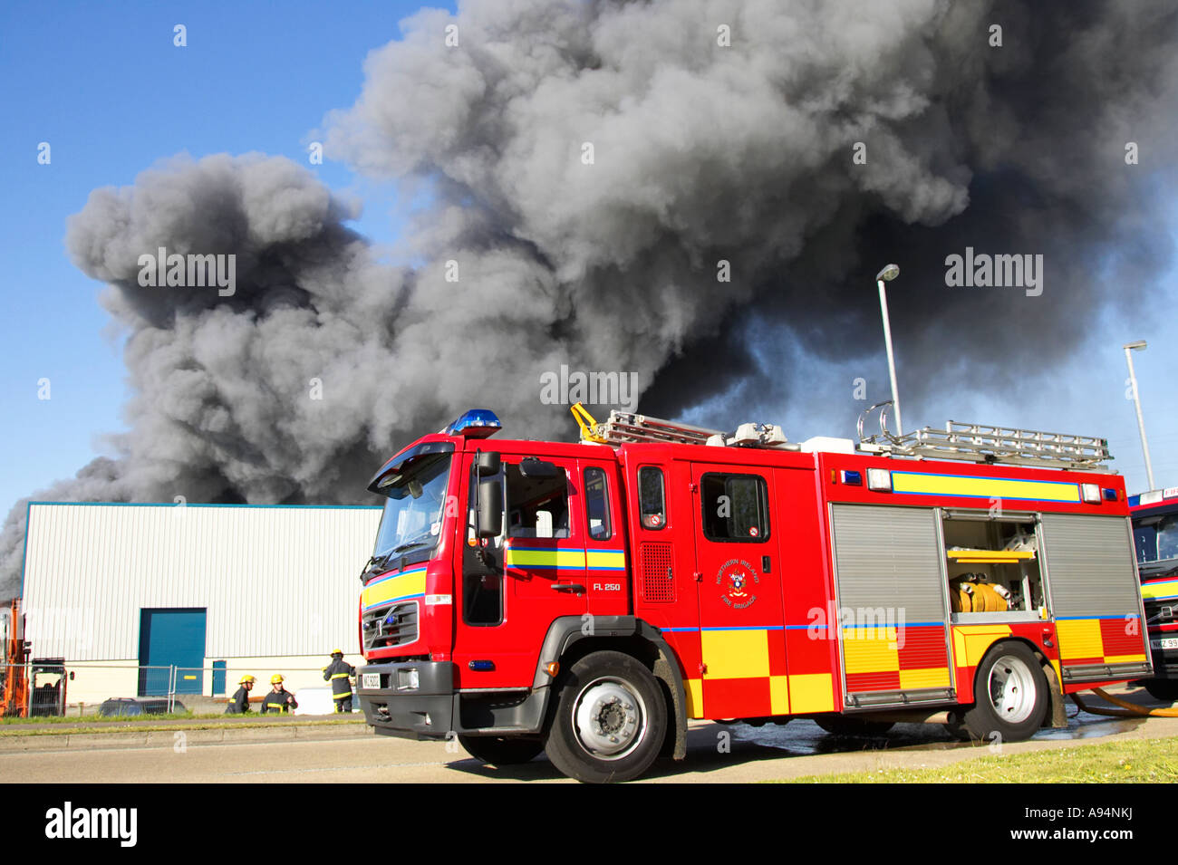 fire engine beneath column of smoke at fire in industrial area Stock ...