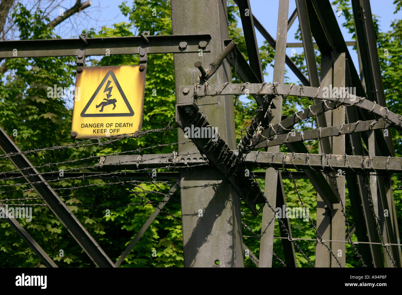 Yellow sign on an electricity supply pylon warning of extreme danger to ...
