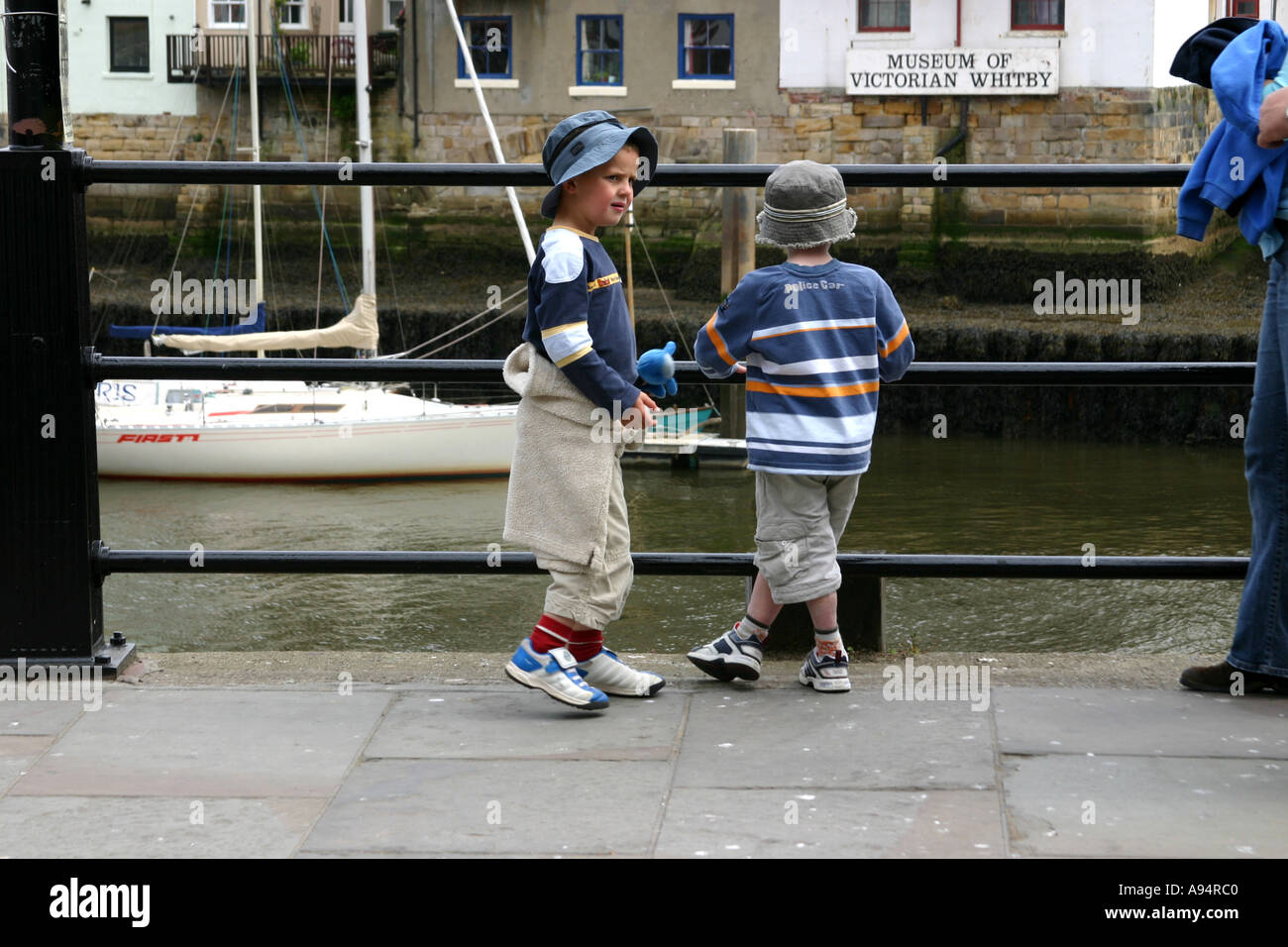 Two Young Lads On The Harbour Wall At Whitby North Yorkshire Stock