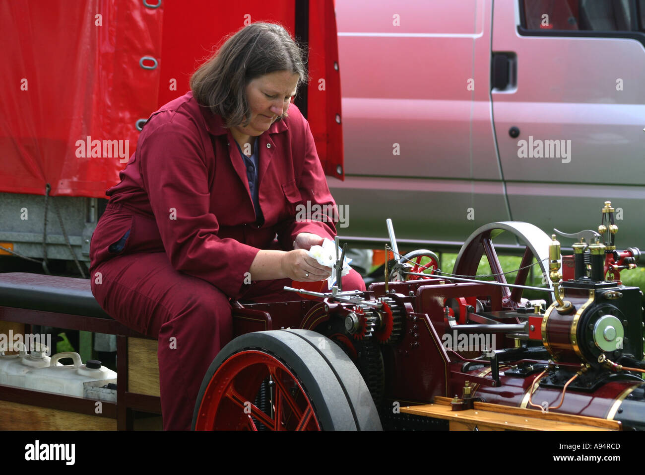 Lady in overalls working on a scale model steam powered traction engine ...