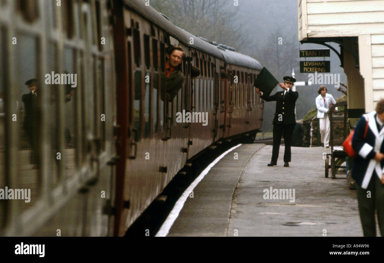 Guard giving signal for the train to leave the station at the preserved ...
