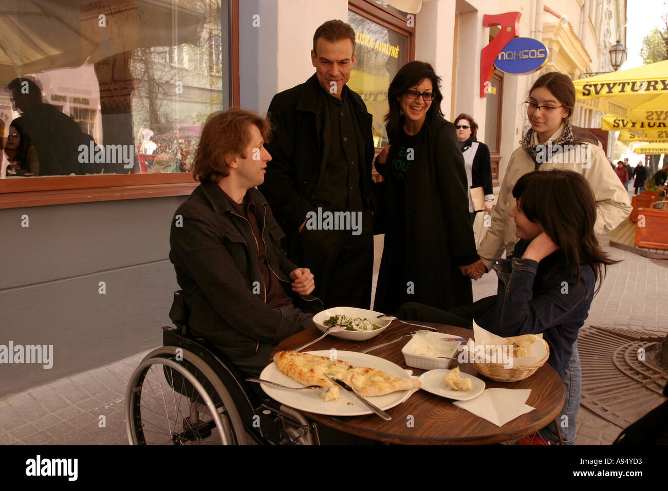 disabled man meeting his friends at an outside a cafe Stock Photo - Alamy