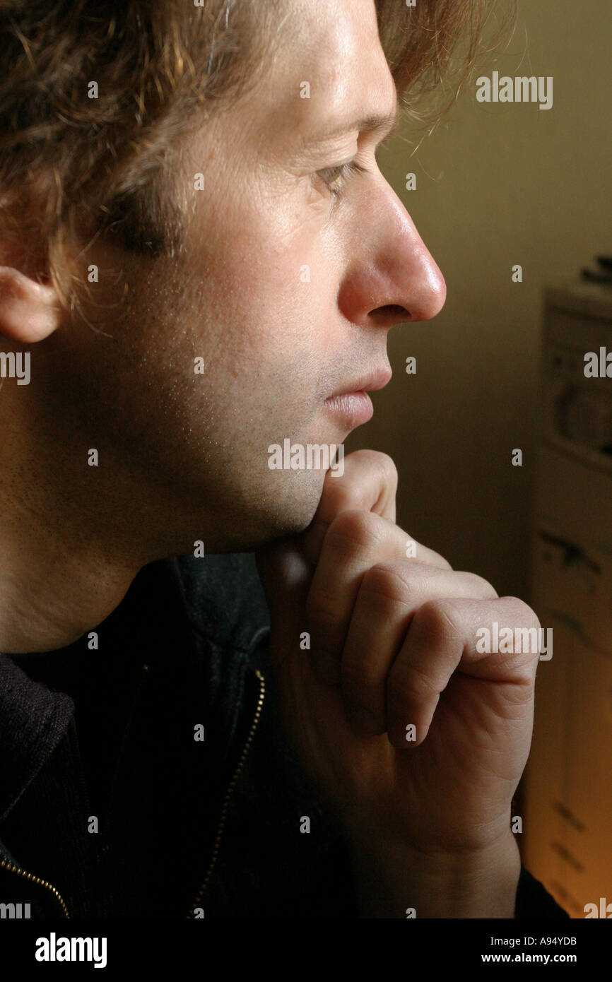 Side profile of young man thinking Stock Photo - Alamy
