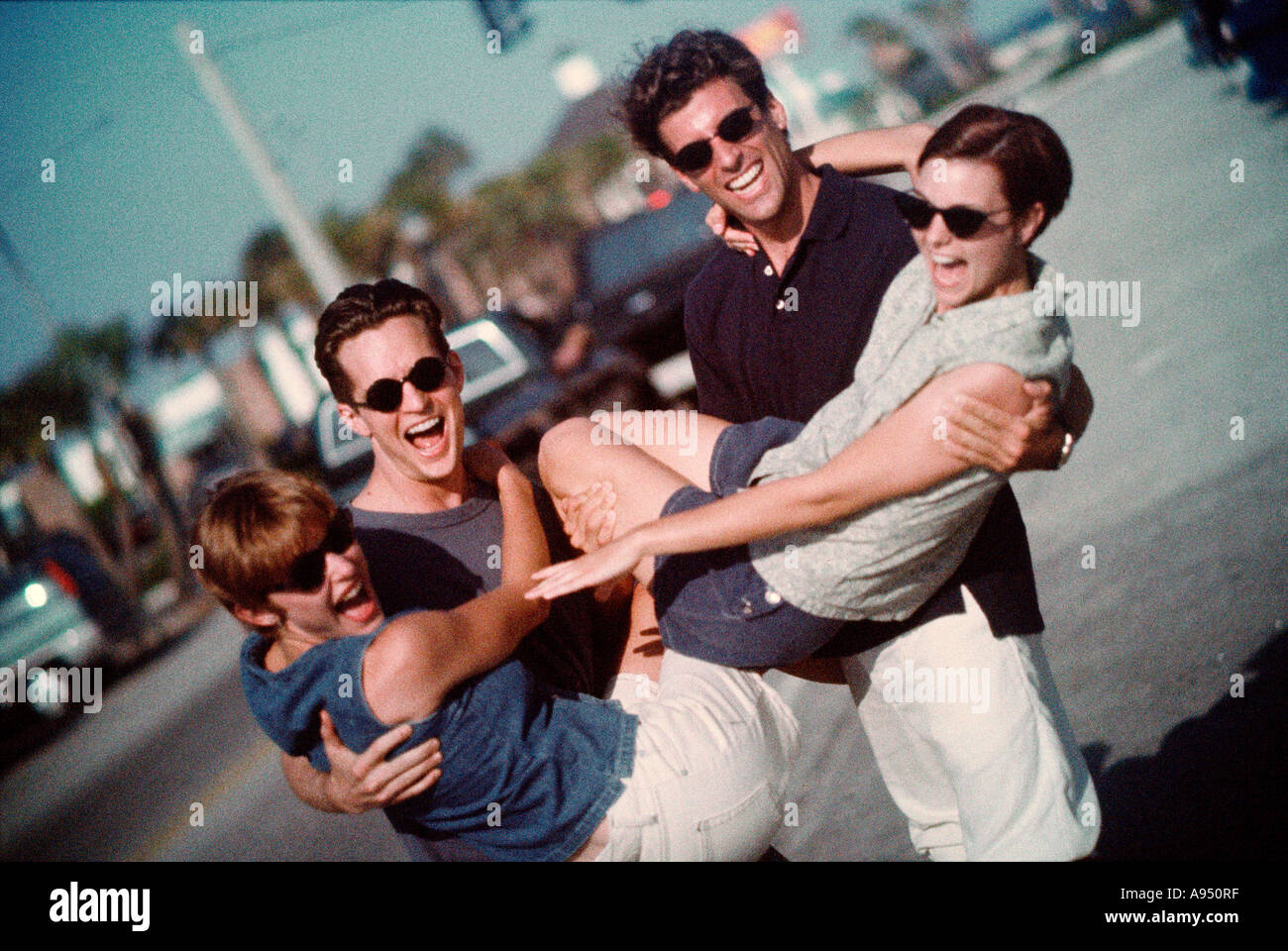 Close-up of two young men carrying two young women Stock Photo - Alamy
