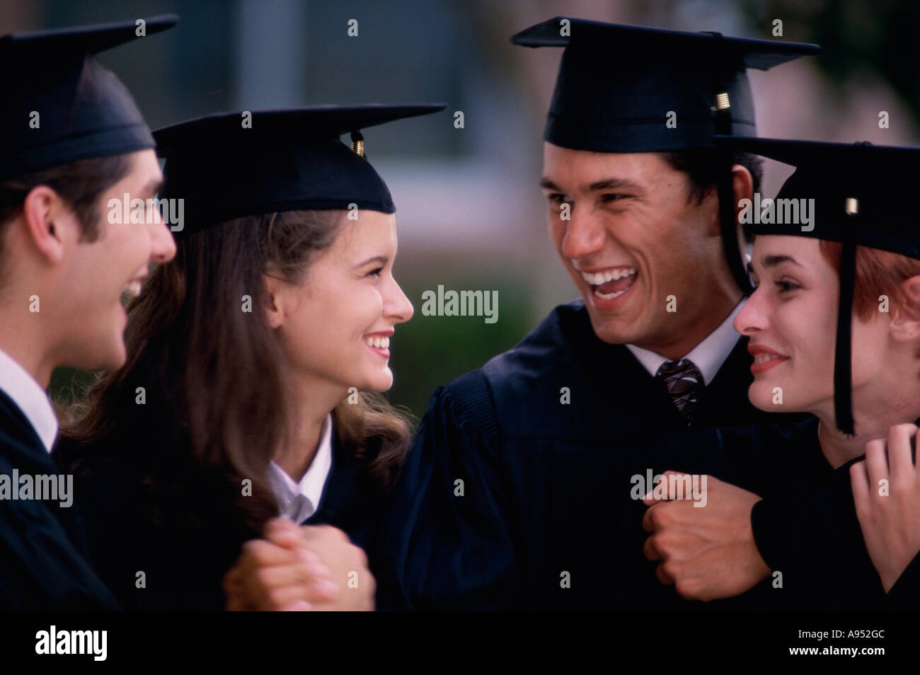 Side profile of four young graduates smiling Stock Photo - Alamy