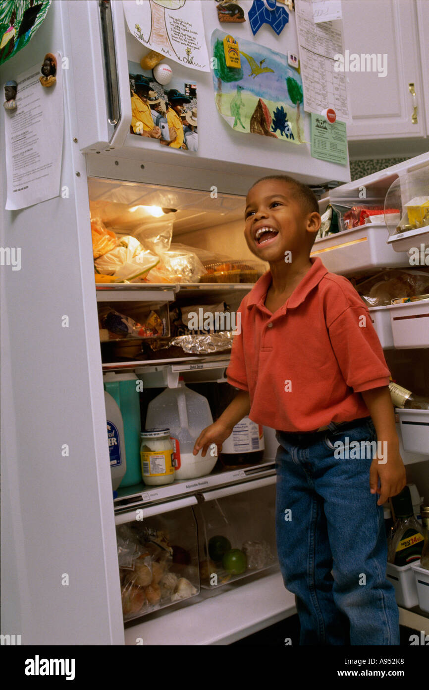 Boy standing in front of an open refrigerator Stock Photo - Alamy