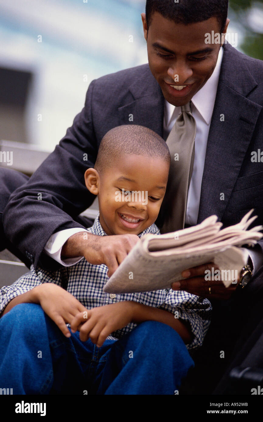 Father and son reading a newspaper Stock Photo - Alamy