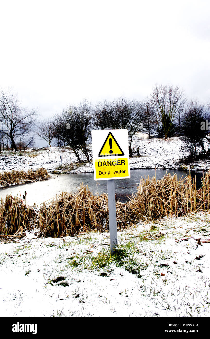 Danger deep water sign next to frozen pond in the countryside Stock ...