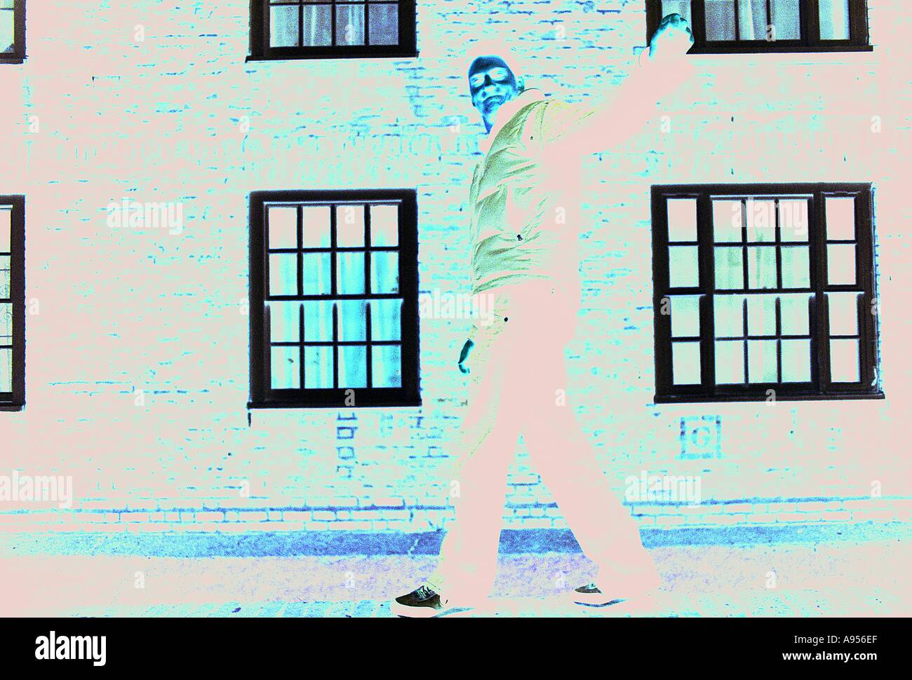 Photograph of man walking by building Stock Photo - Alamy