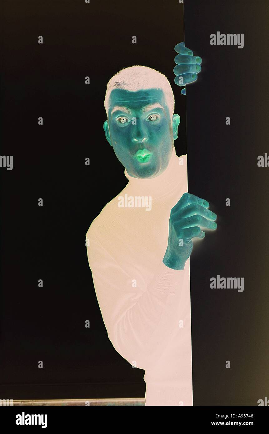 Photograph of man looking around wall Stock Photo - Alamy