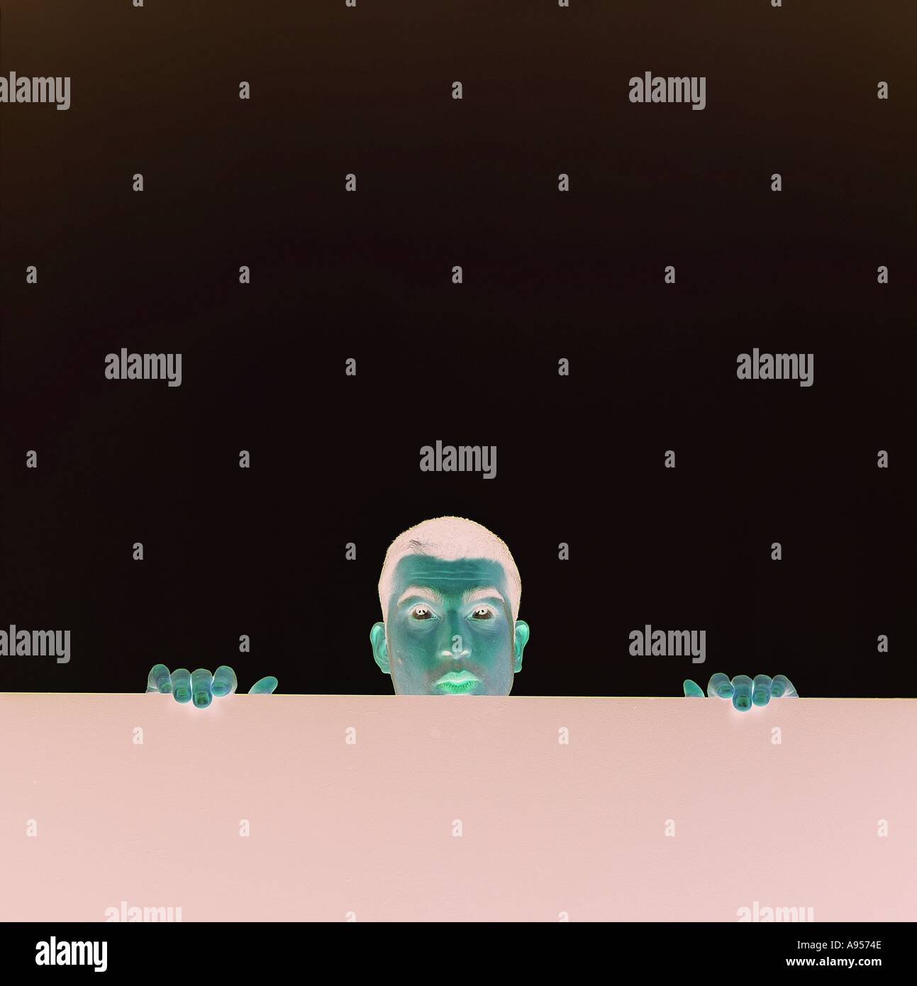 Photograph of man looking over wall Stock Photo - Alamy