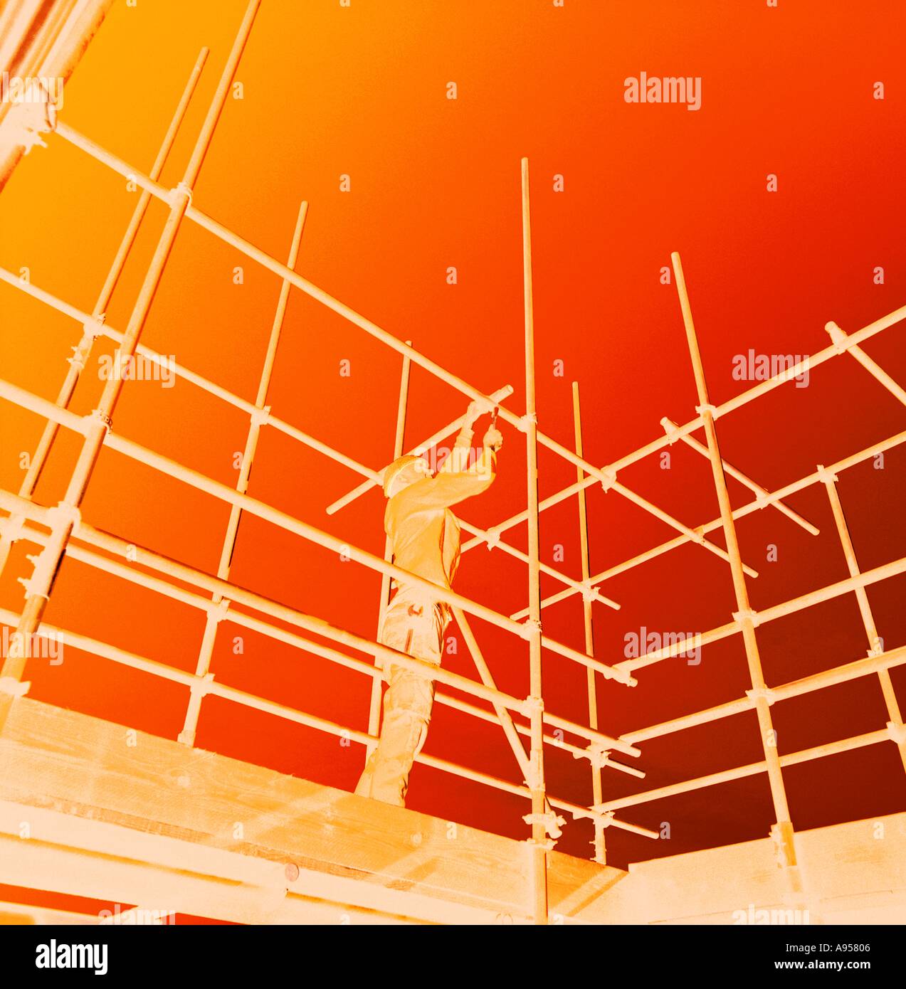 Photograph of construction worker building scaffolding structure on ...