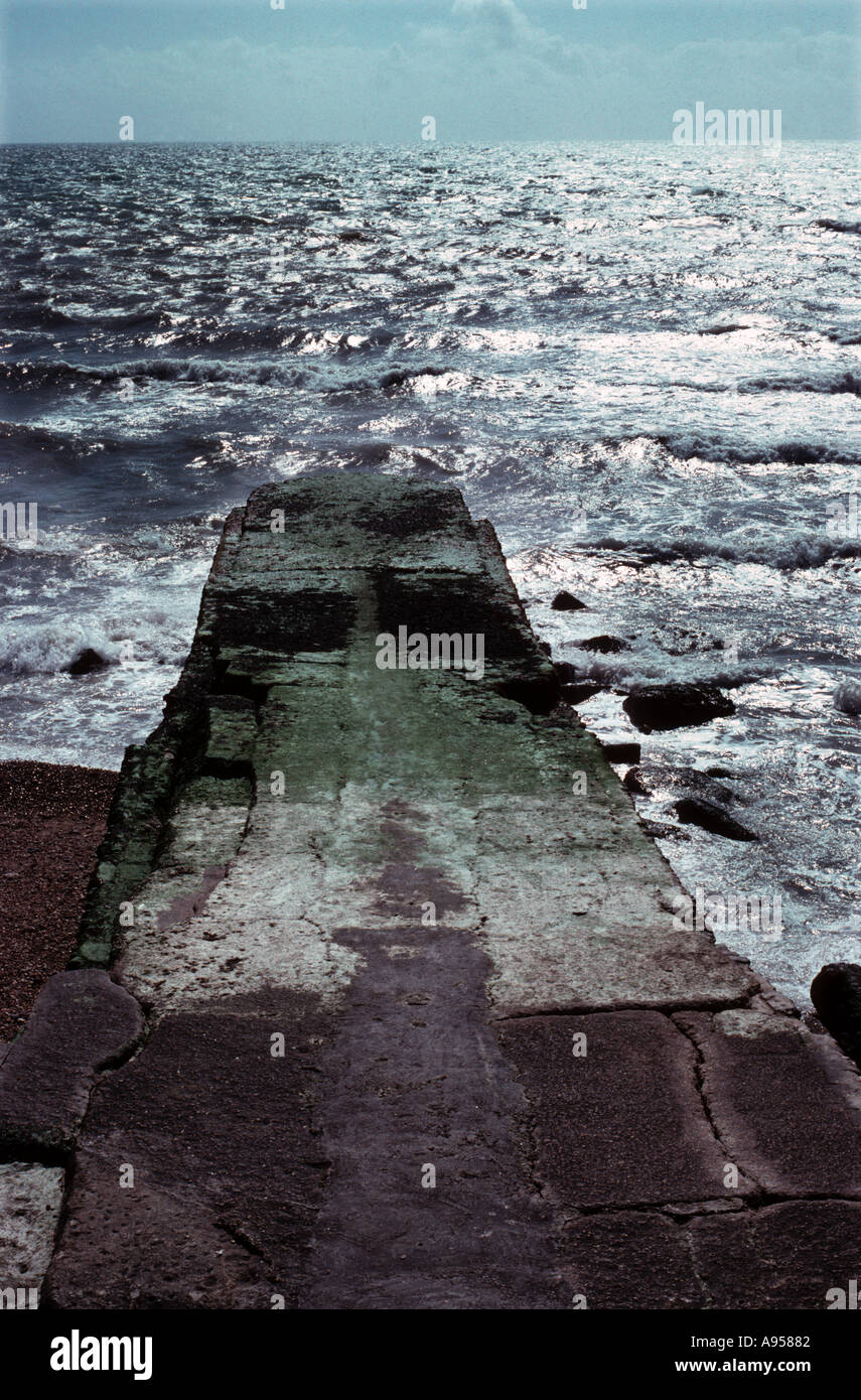 Sea jetty with waves in backlight Stock Photo - Alamy