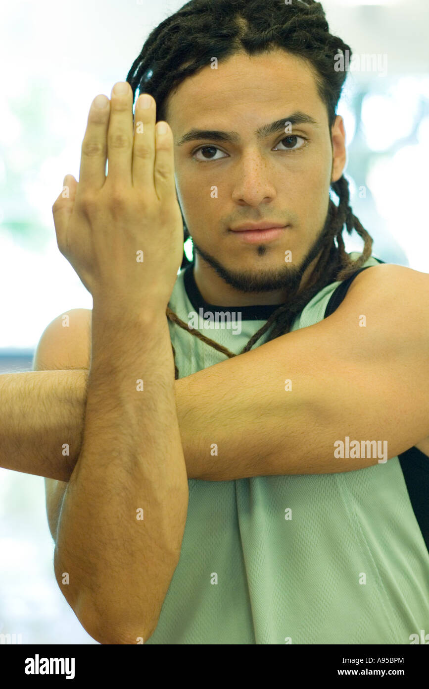 Man doing arm stretch, portrait Stock Photo - Alamy