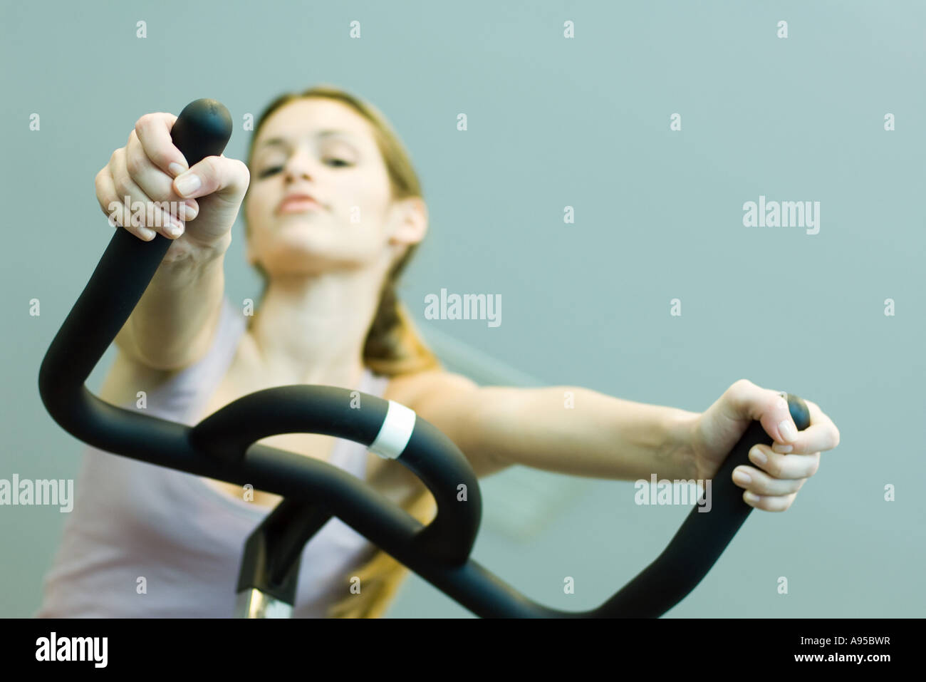 Woman riding exercise bike Stock Photo - Alamy