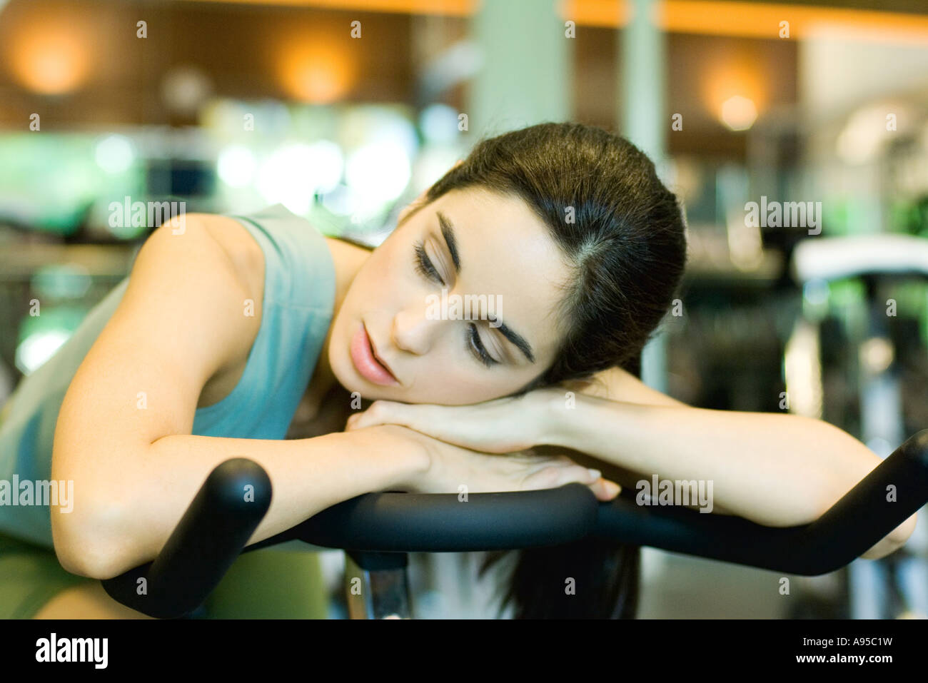 Woman resting on exercise bike Stock Photo - Alamy