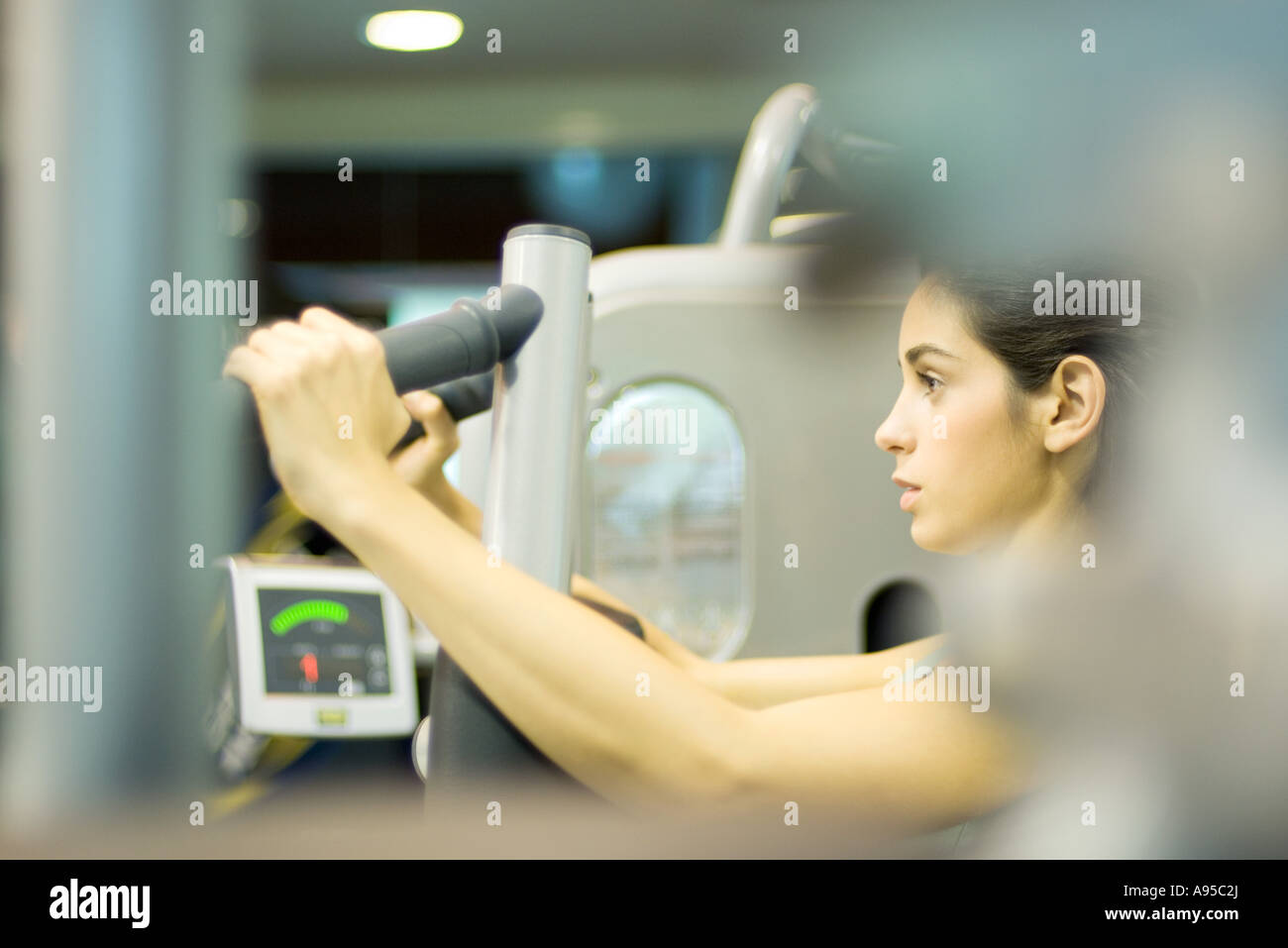 Woman using weight machine, side view Stock Photo - Alamy