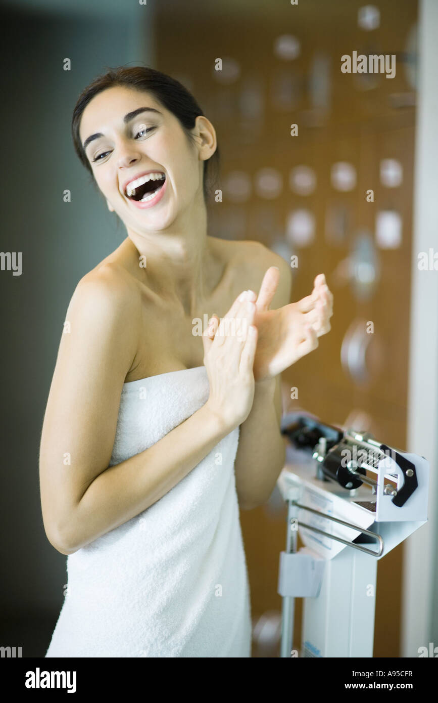 Young woman standing on scale, laughing Stock Photo - Alamy