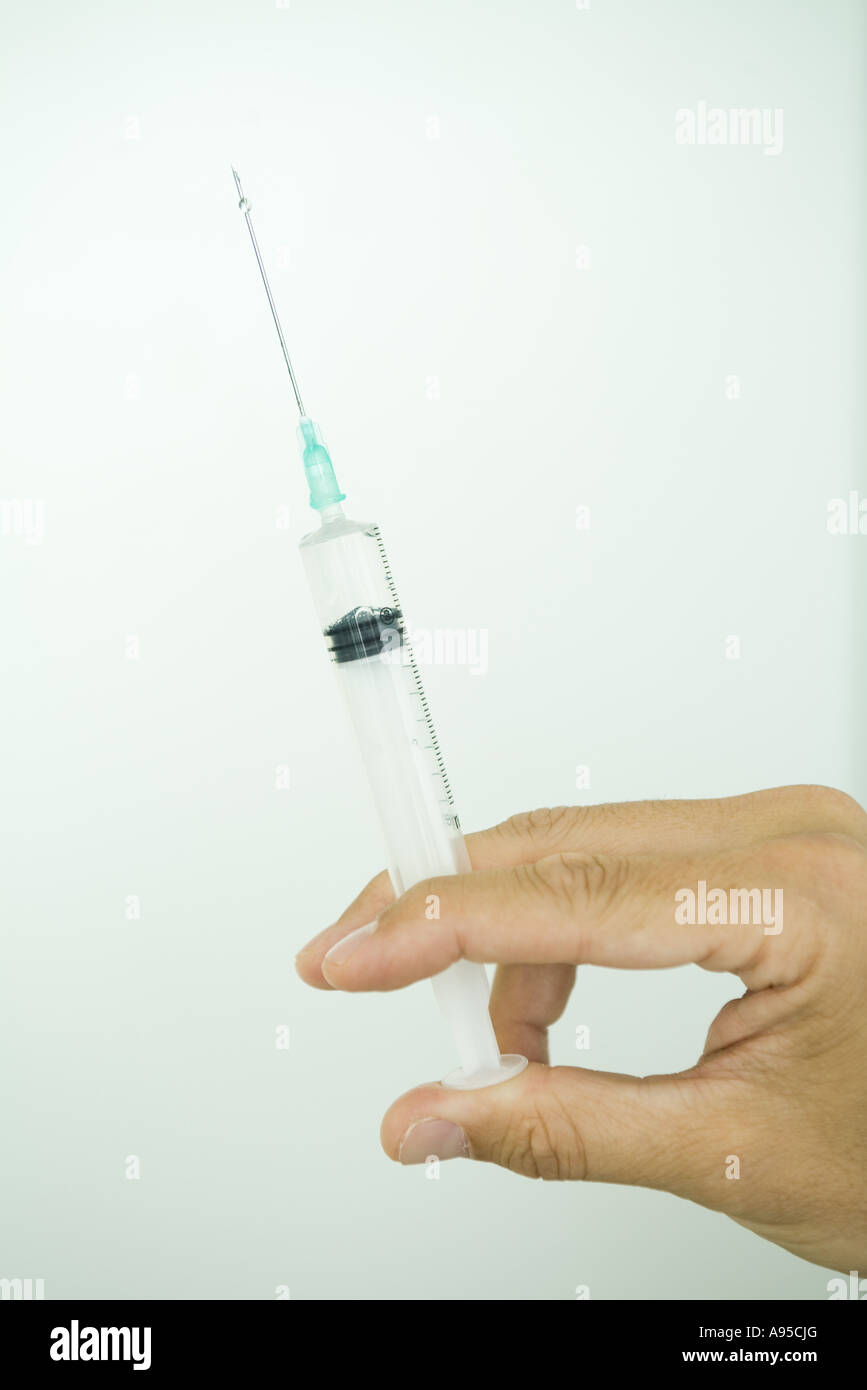 Hand holding syringe Stock Photo - Alamy