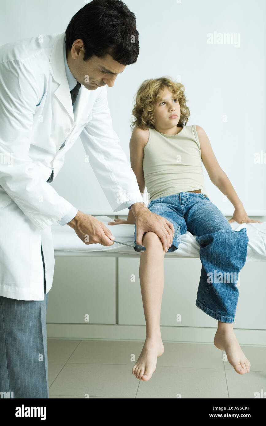 Doctor checking boy's reflexes Stock Photo - Alamy
