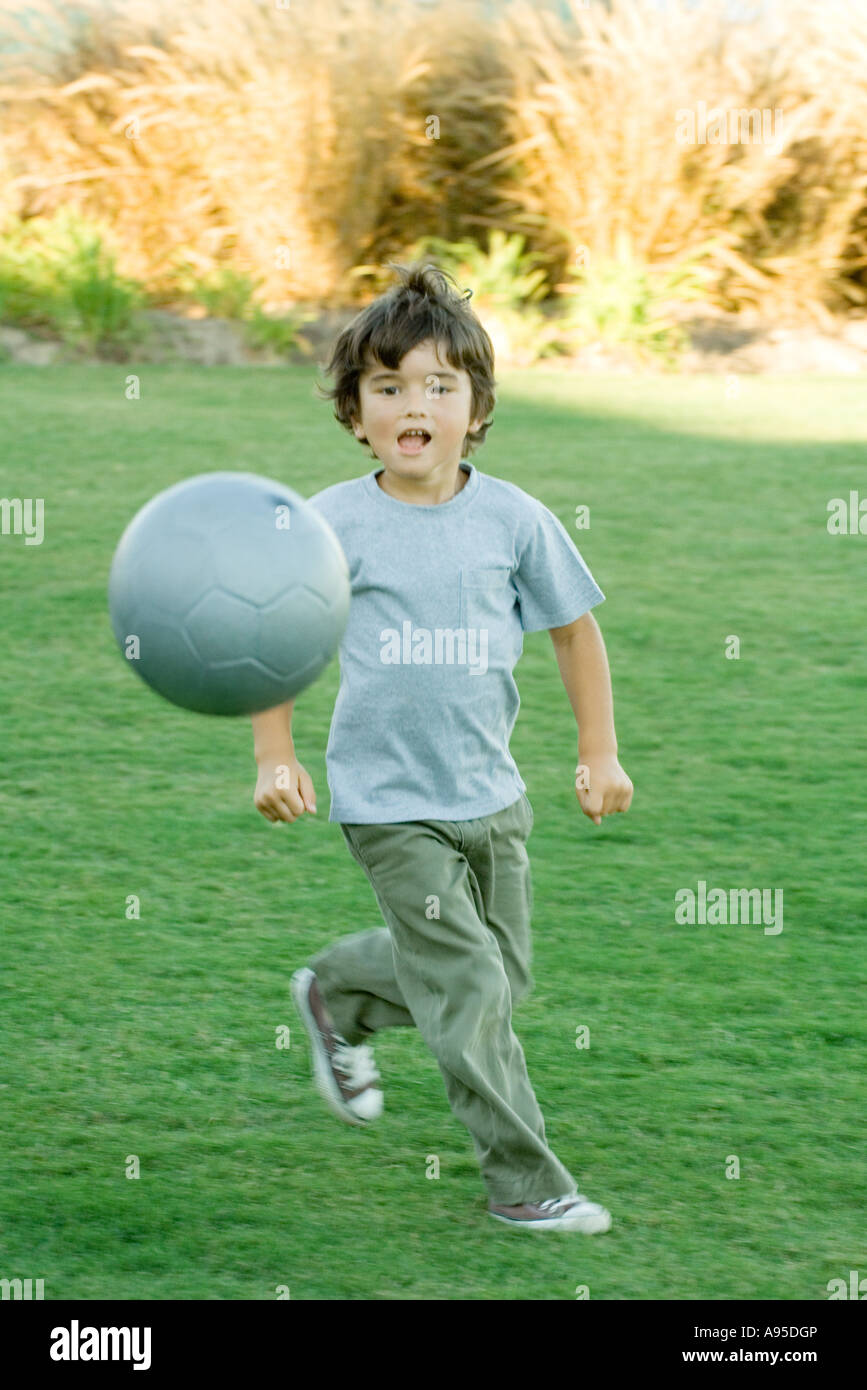 Boy running after ball Stock Photo - Alamy