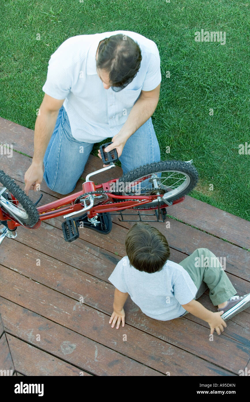 Father helping son fix bicycle hi-res stock photography and images - Alamy