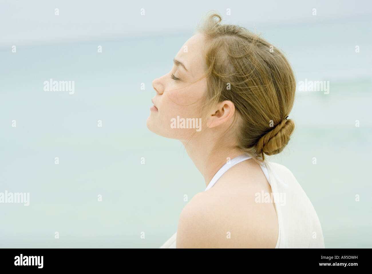 Young woman, head and shoulders, side view, sea in background Stock ...